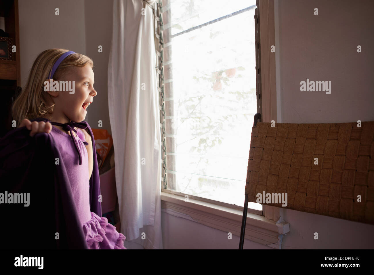 Portrait of young girl looking out of window Stock Photo - Alamy