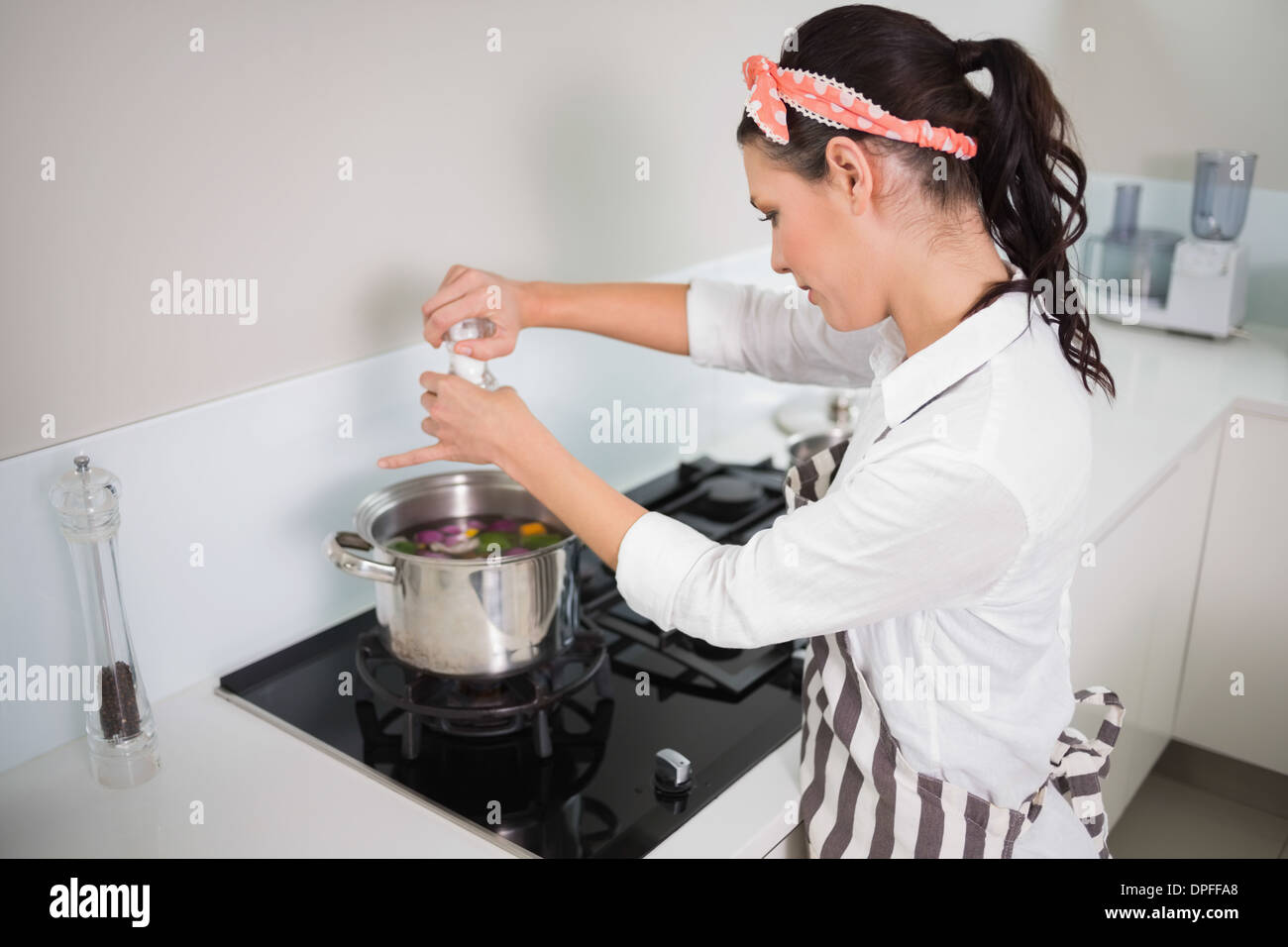 Focused gorgeous cook putting salt on vegetables Stock Photo - Alamy