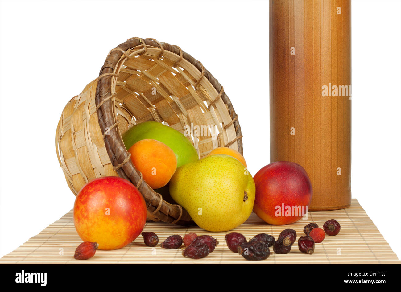 Fruit spill out of the basket on a bed of straw isolated on white ...