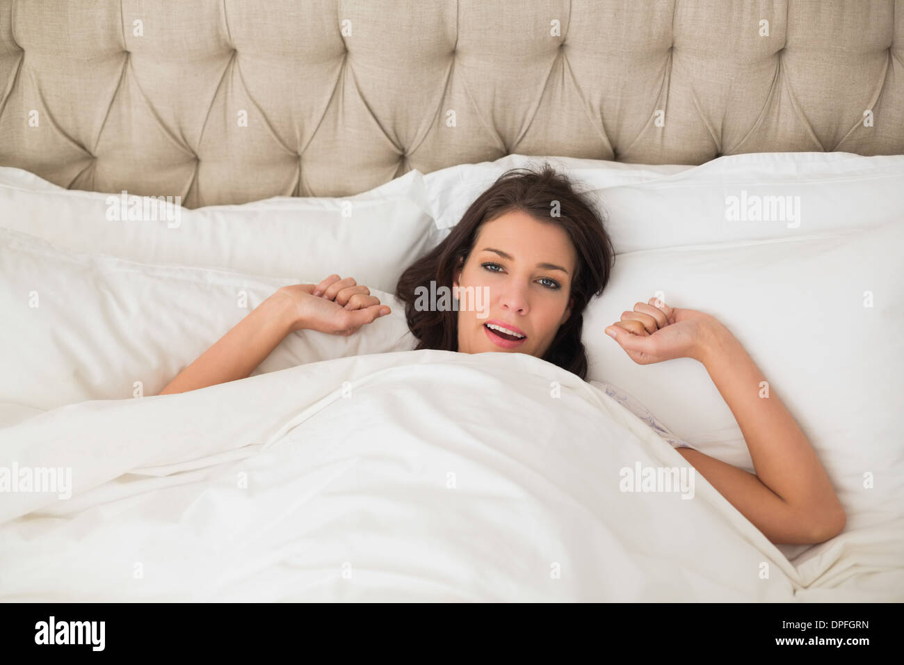 Content pretty brown haired woman waking up Stock Photo - Alamy