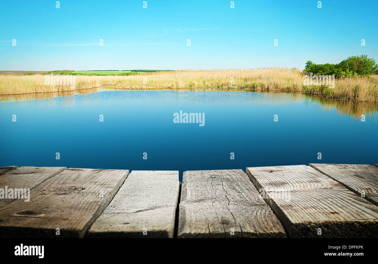 Pier overlooking the lake with blue water Stock Photo - Alamy