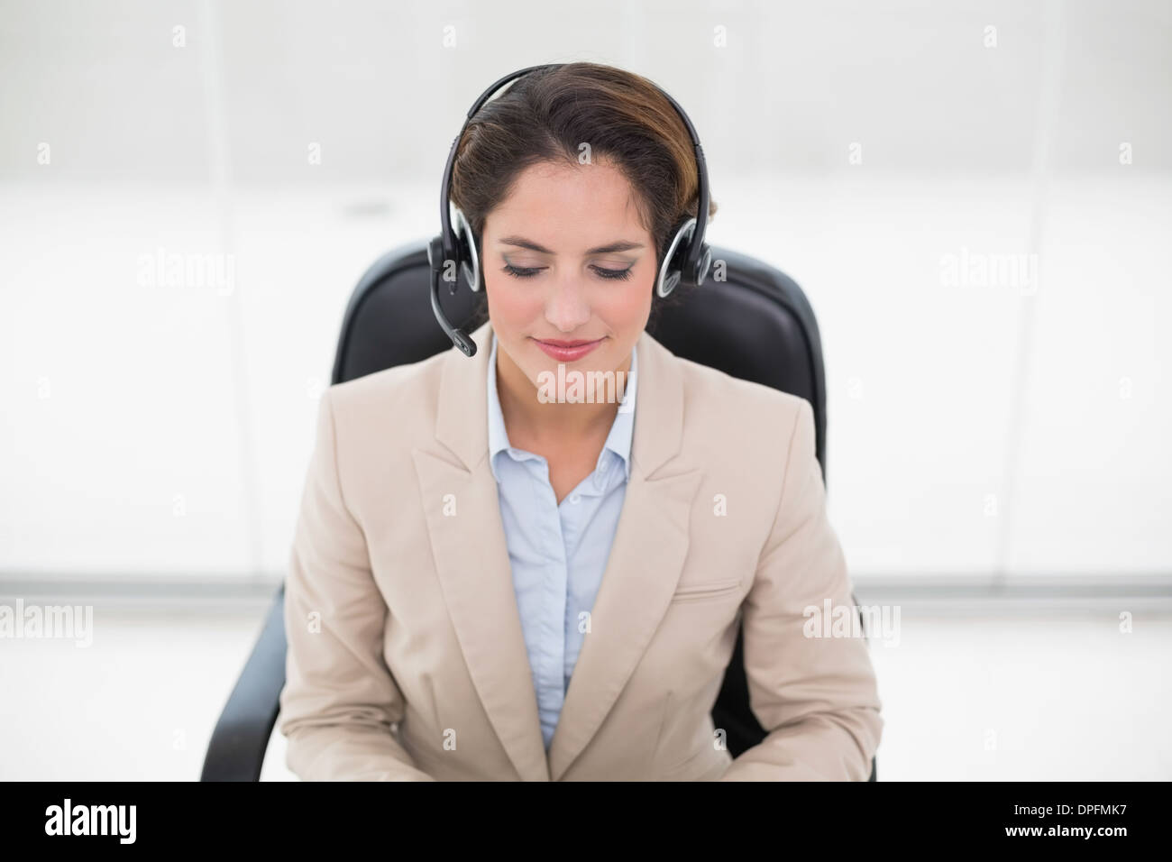 Happy call center agent sitting in swivel chair Stock Photo - Alamy