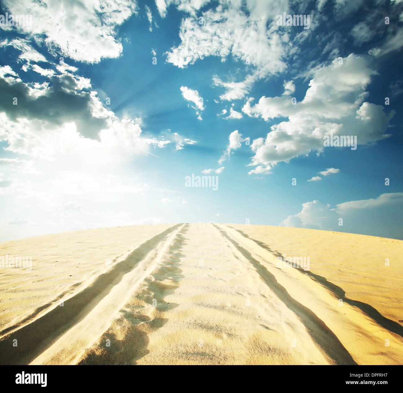 Sandy road in the desert under a blue sky Stock Photo - Alamy