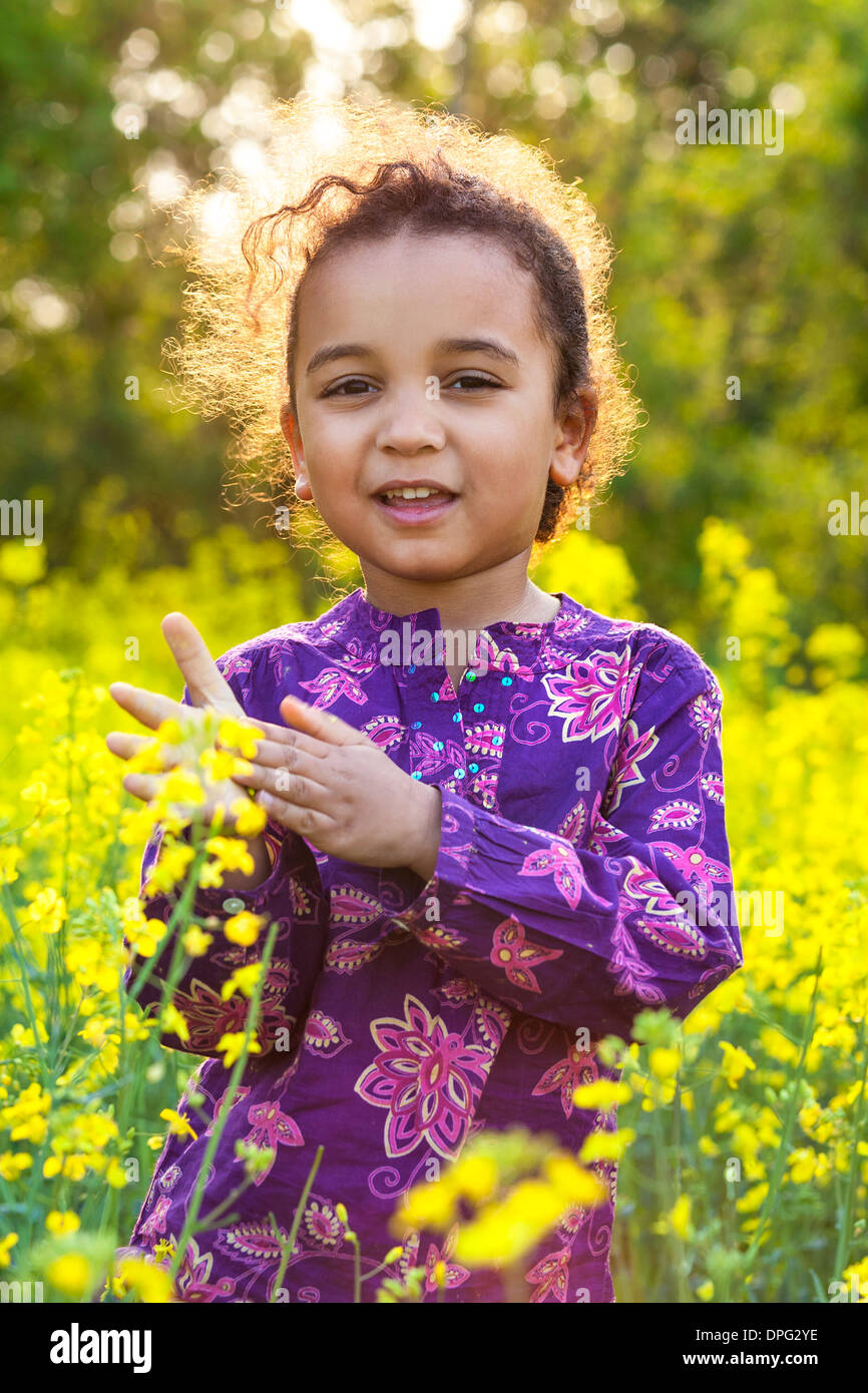 Mixed race African American female girl child back lit in a field of ...