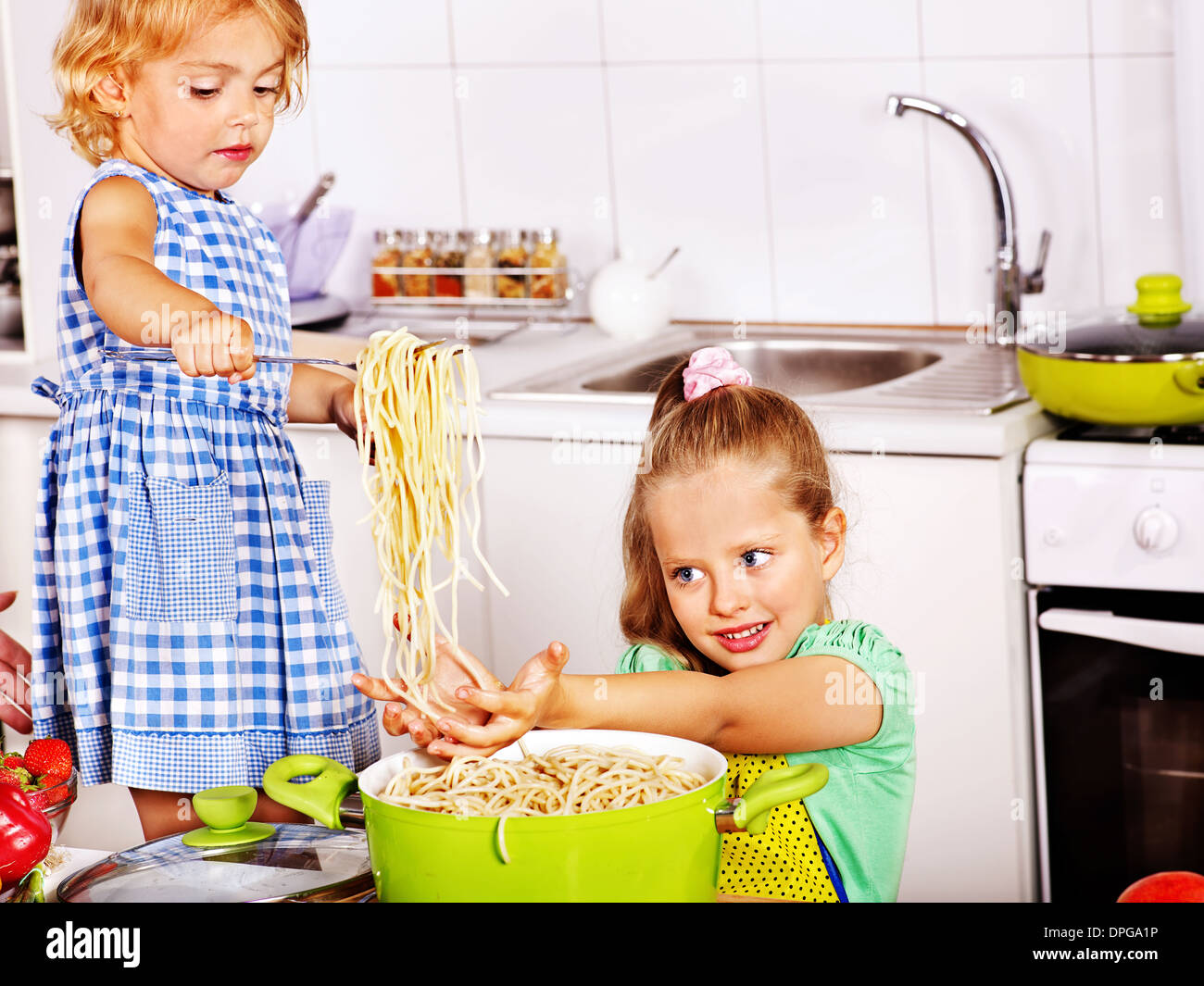 Children eating spaghetti at kitchen Stock Photo - Alamy
