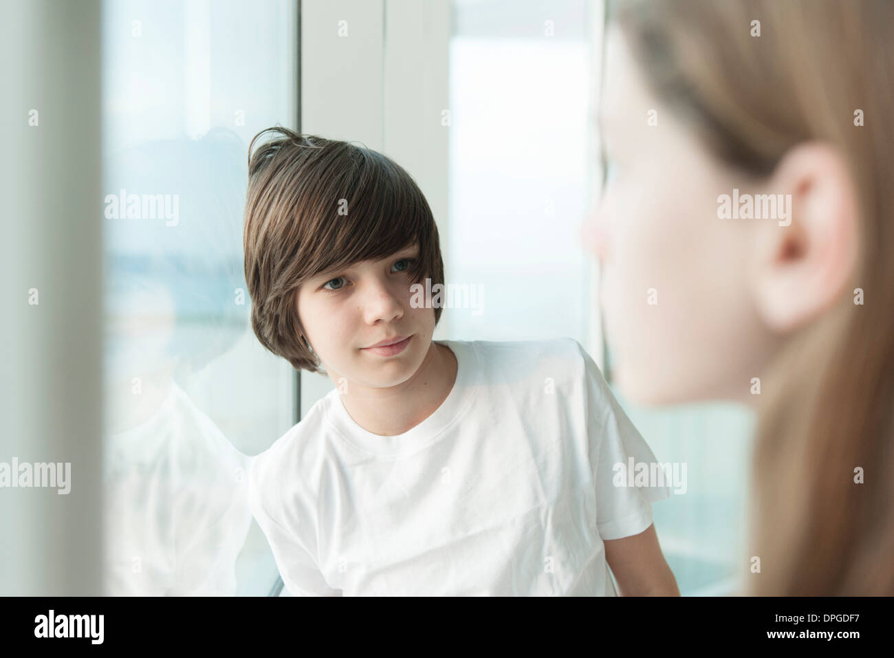 Teenage boy leaning against window Stock Photo - Alamy