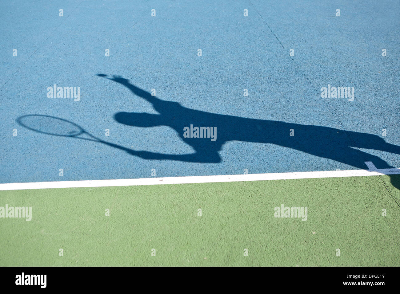 Shadow of tennis player serving ball Stock Photo - Alamy