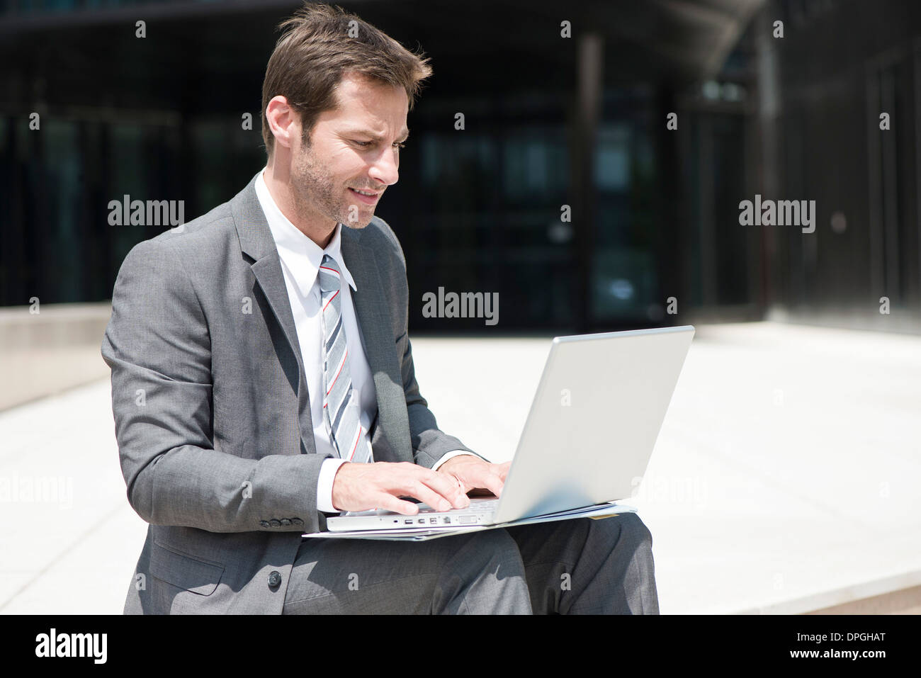 Businessman using laptop outdoors Stock Photo - Alamy