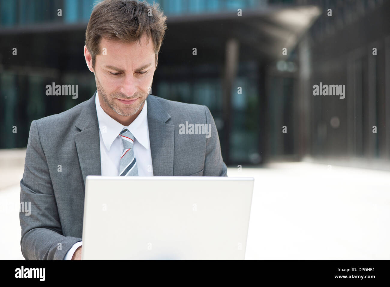 Businessman using laptop outdoors Stock Photo - Alamy