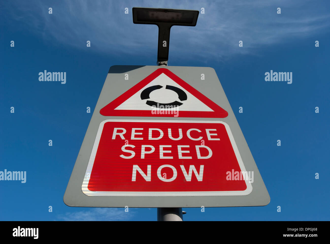 british road sign indicating a roundabout ahead and instructing reduce ...