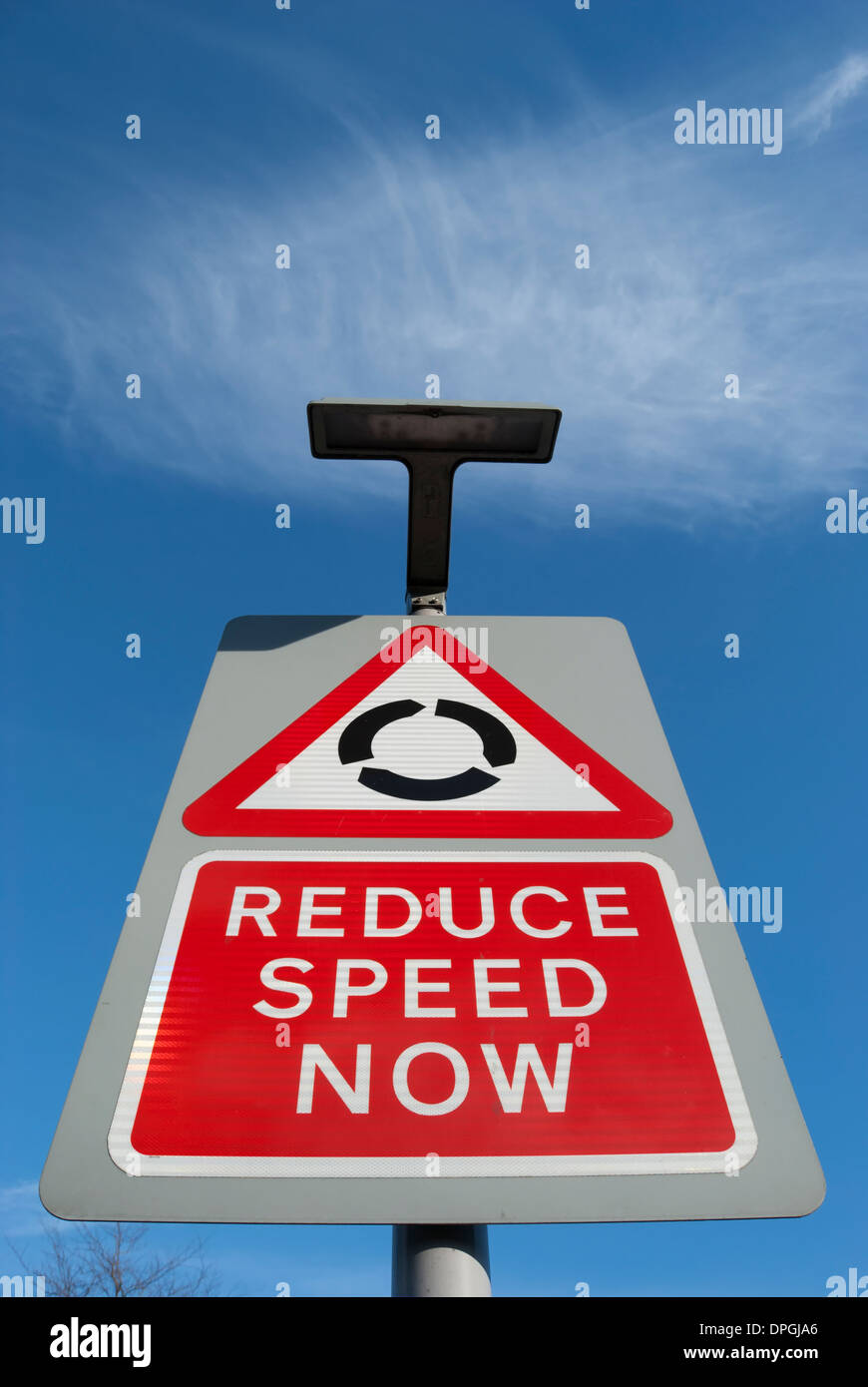 british road sign indicating a roundabout ahead and instructing reduce ...