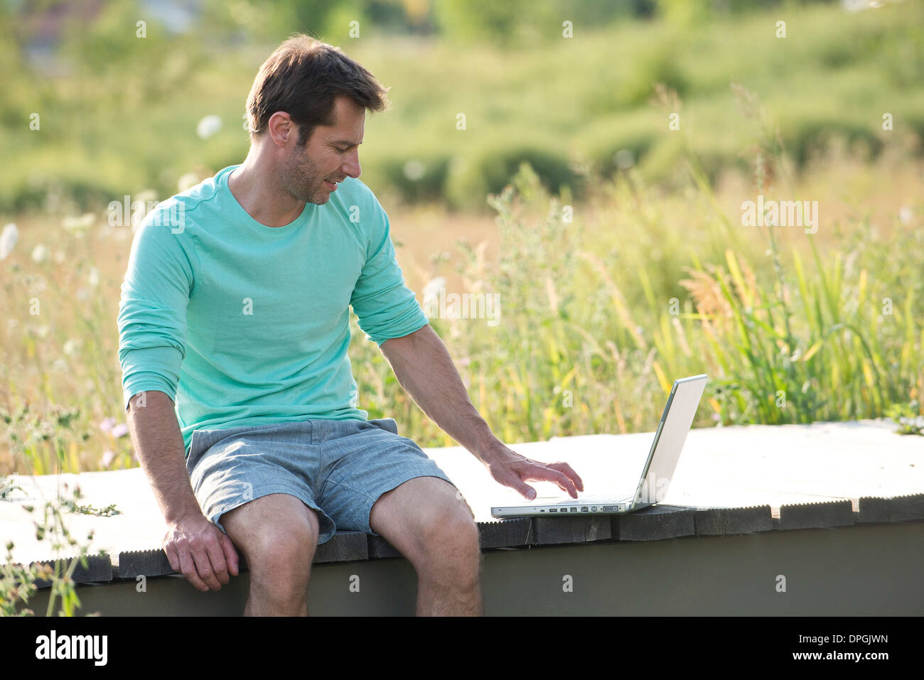 Man using laptop computer outdoors Stock Photo - Alamy
