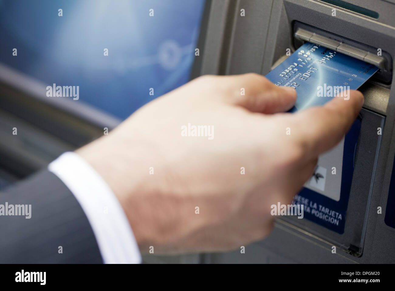 Inserting bank card into ATM to perform automated banking transaction ...