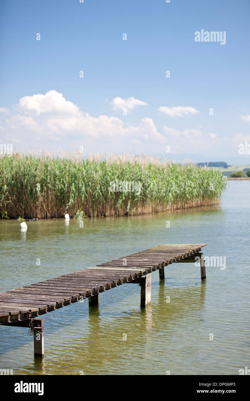 Pier over water, embankment in background Stock Photo - Alamy