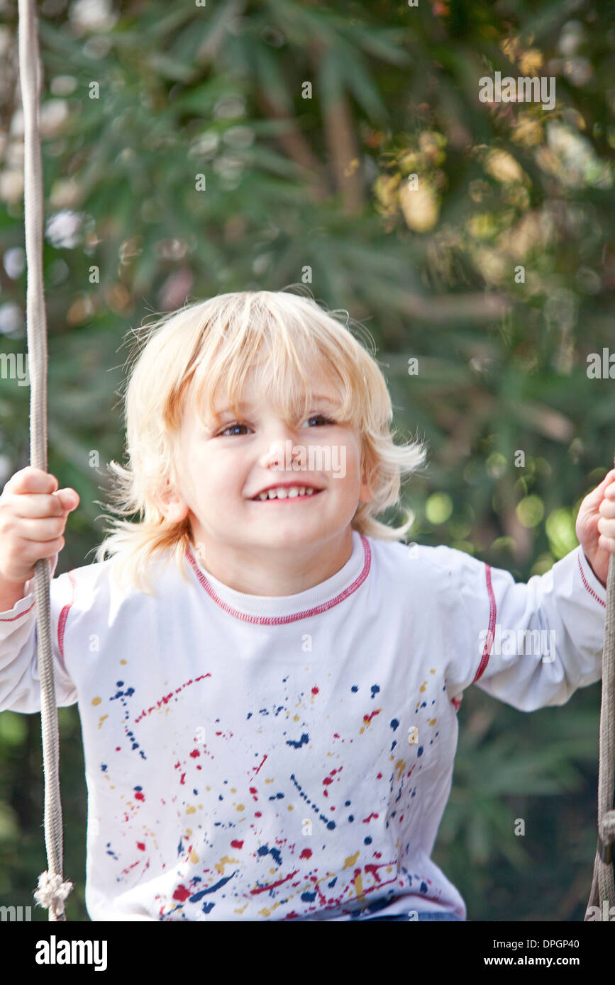 Little boy playing on swing Stock Photo - Alamy