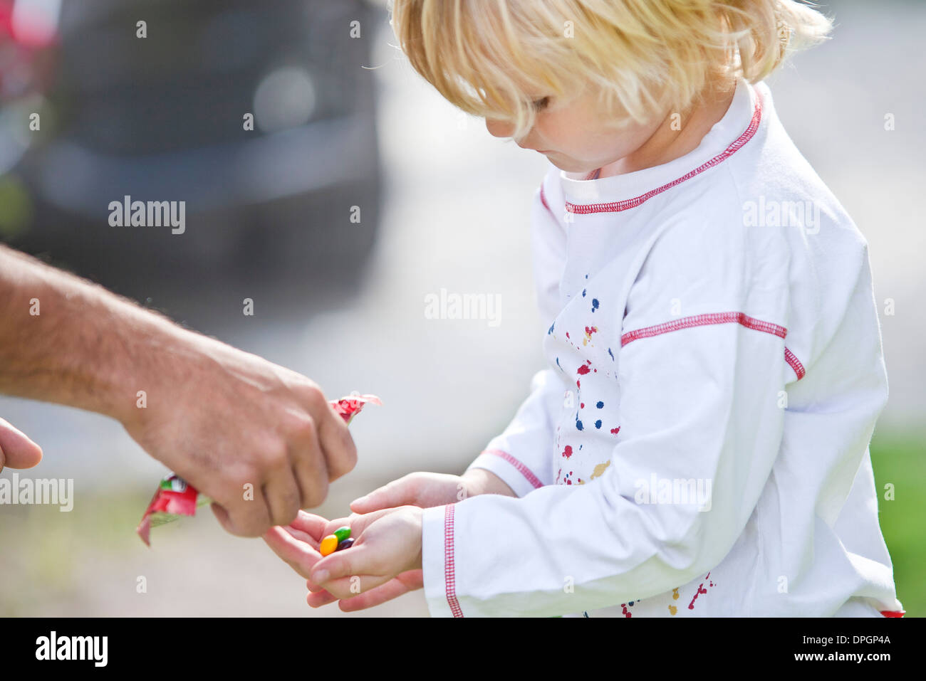 Man giving child candies Stock Photo - Alamy