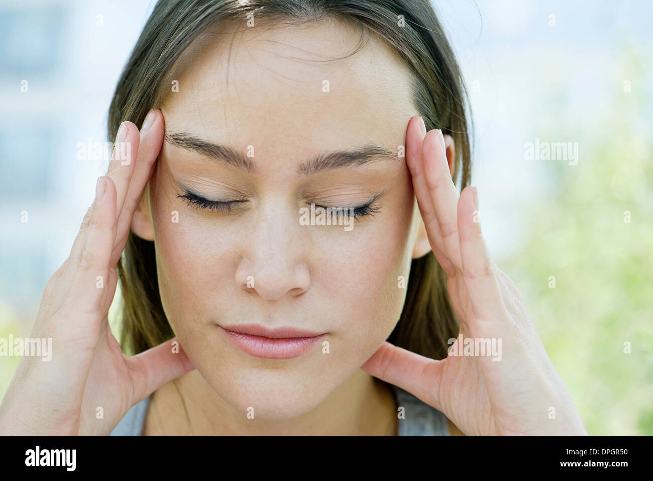 Woman rubbing temples Stock Photo - Alamy