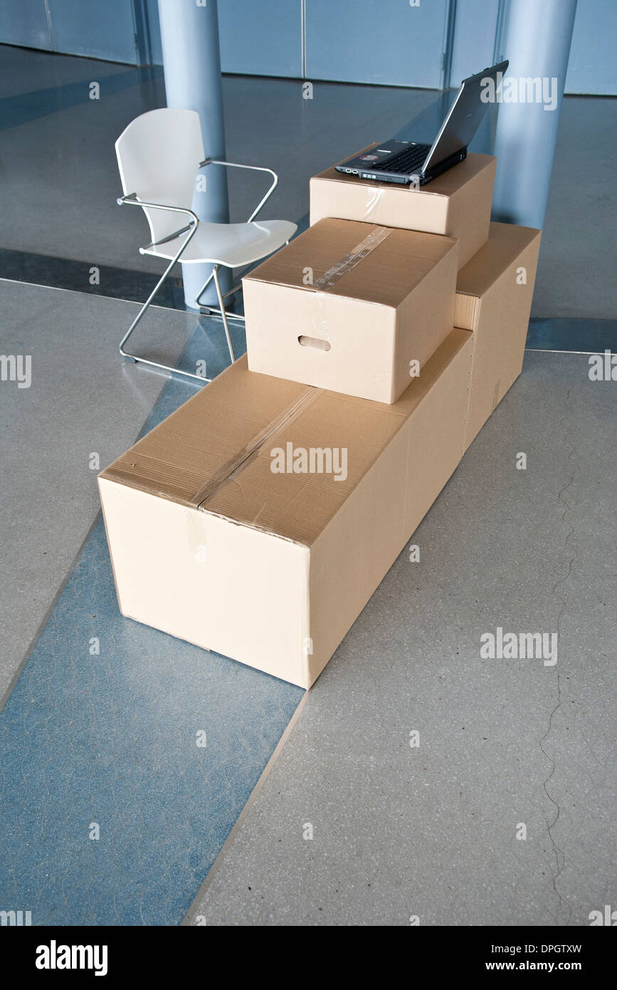 Laptop computer resting on cardboard boxes in empty office Stock Photo ...