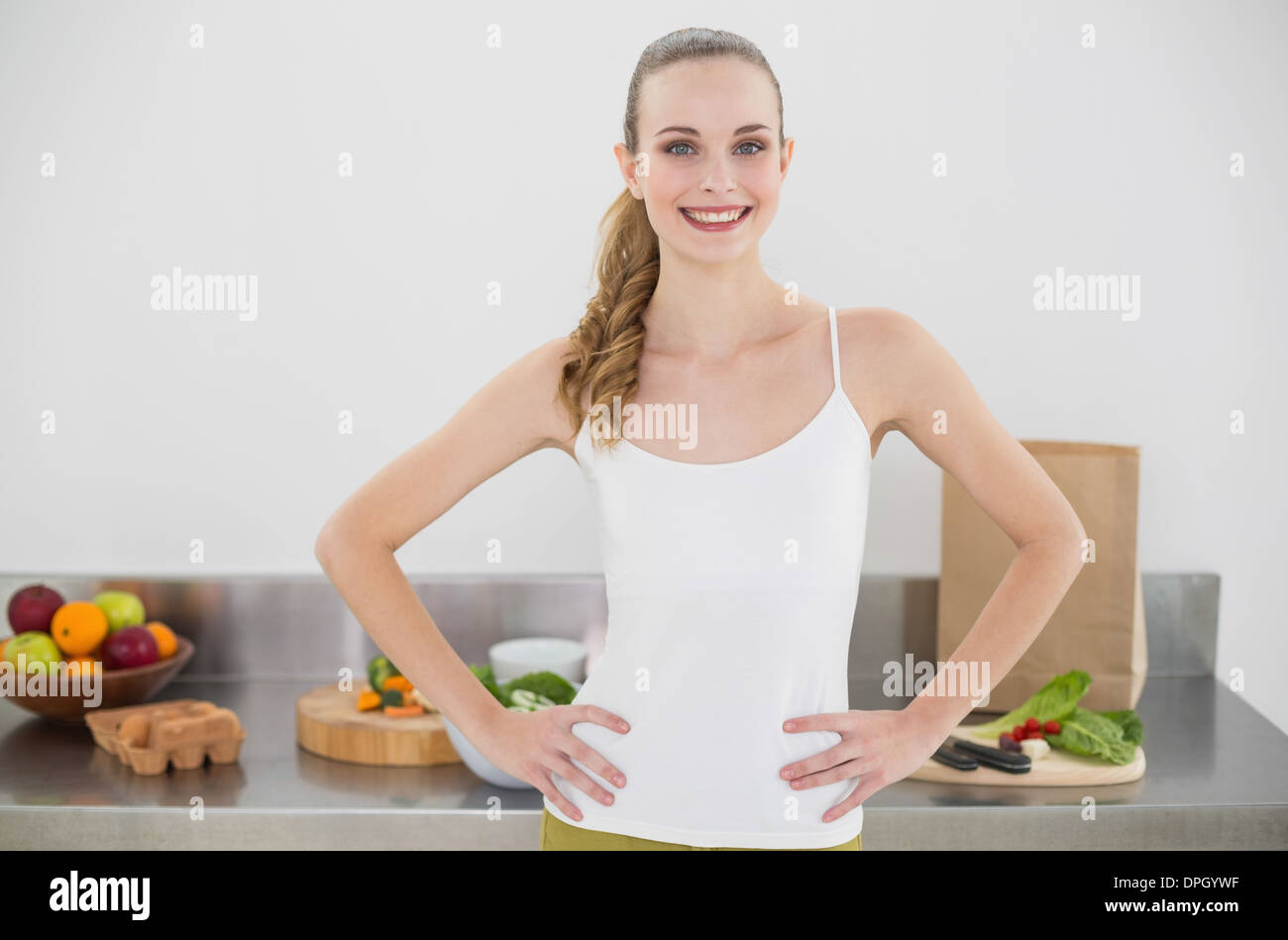 Pretty smiling woman standing hands on hips Stock Photo - Alamy