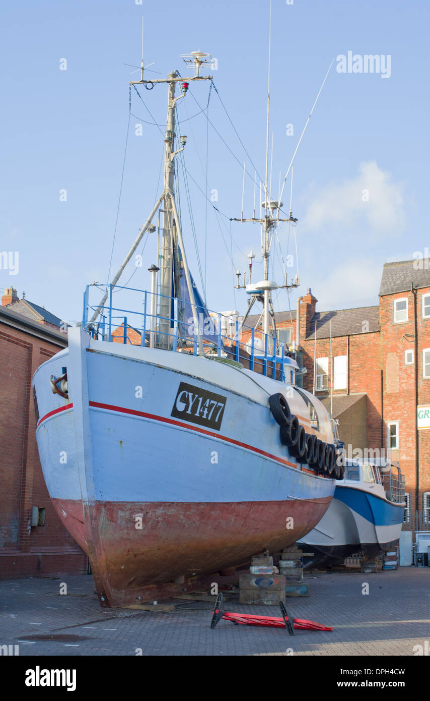 Local fishing boat on hard standing for repainting and maintenance out ...