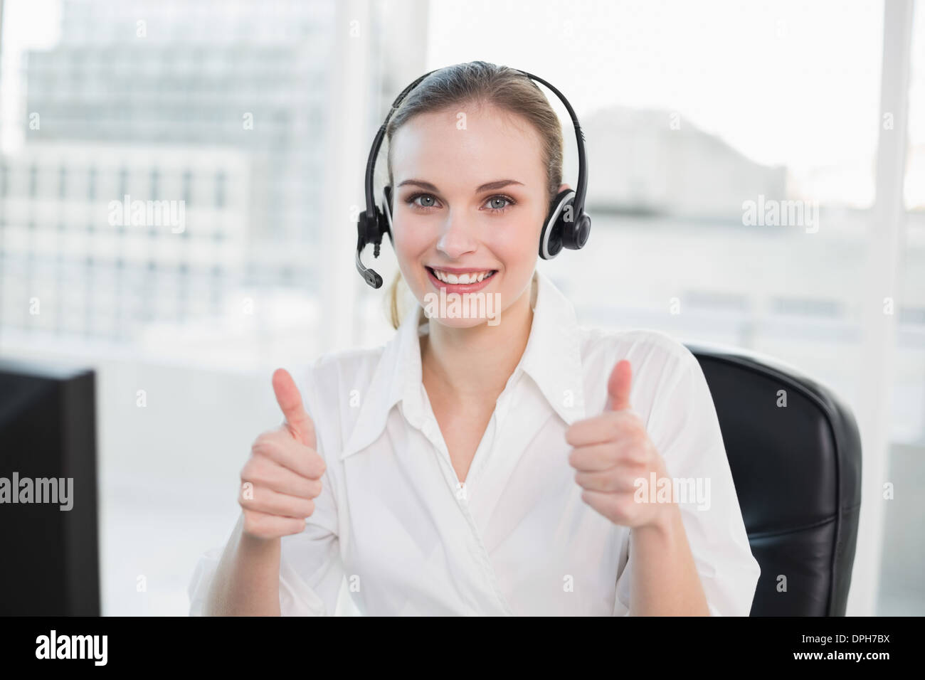 Happy call centre agent looking at camera giving thumbs up Stock Photo ...