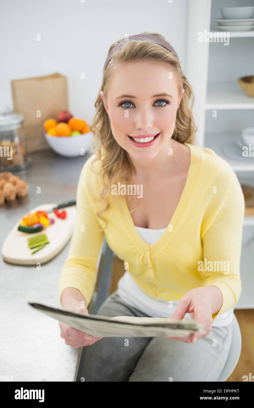 Happy cute blonde holding newspaper Stock Photo - Alamy
