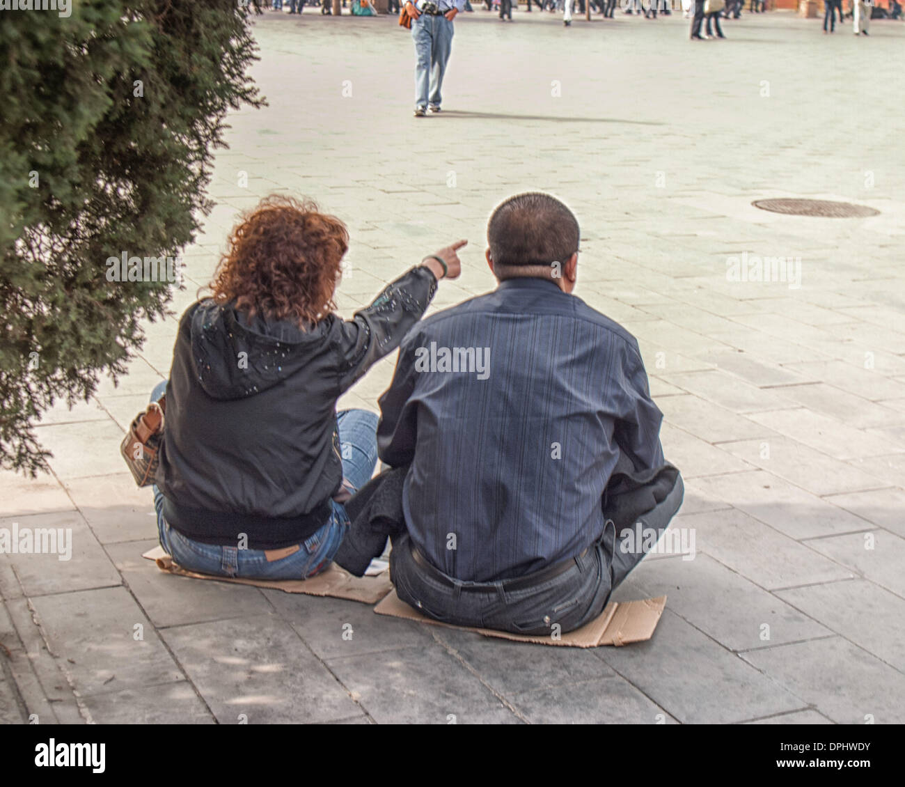 Beijing, China. 16th Oct, 2006. A Chinese couple rest on cardboard as ...