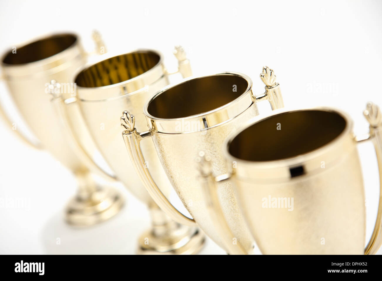 Four gold trophies in a row Stock Photo - Alamy