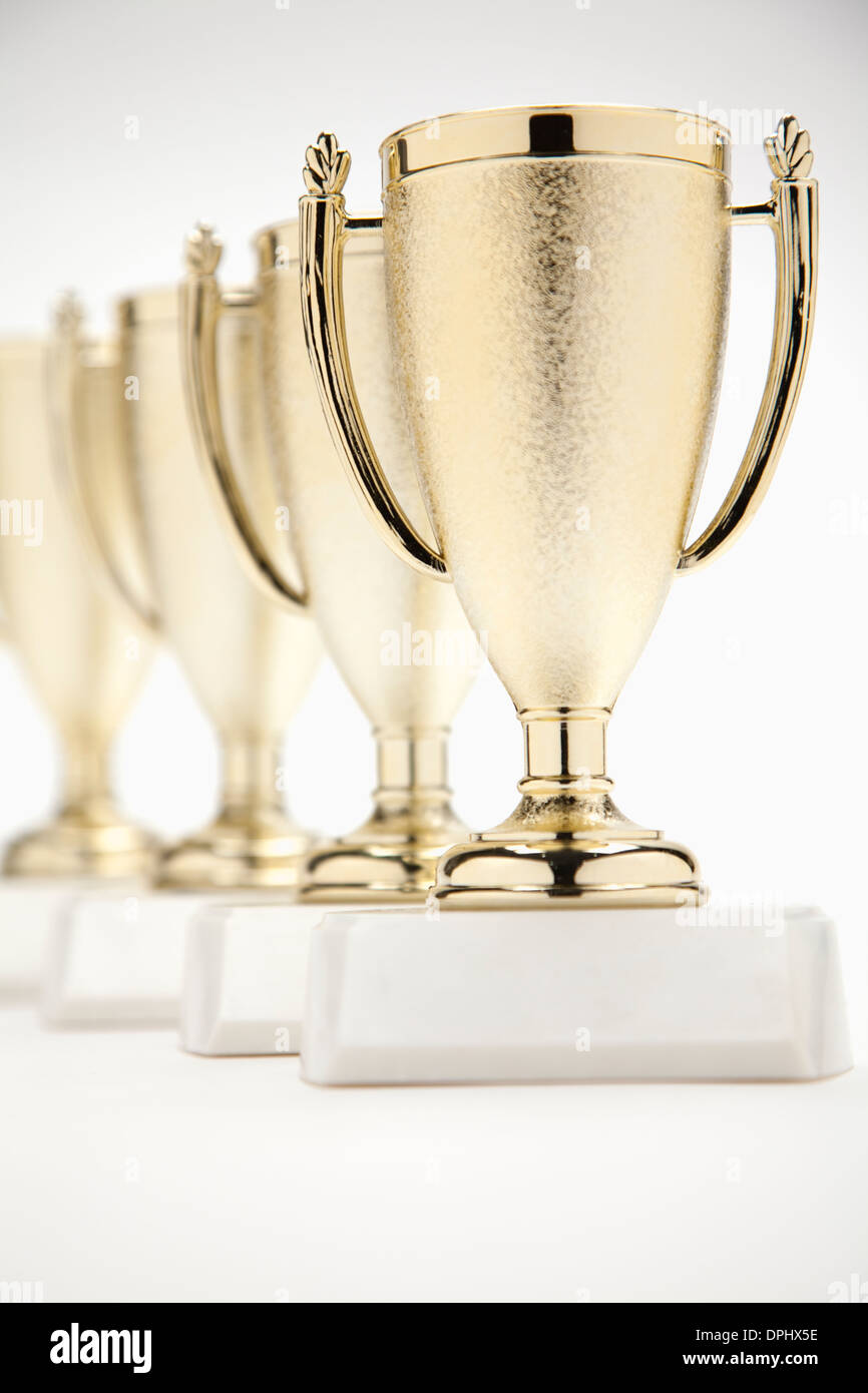 Four gold trophies in a row Stock Photo - Alamy