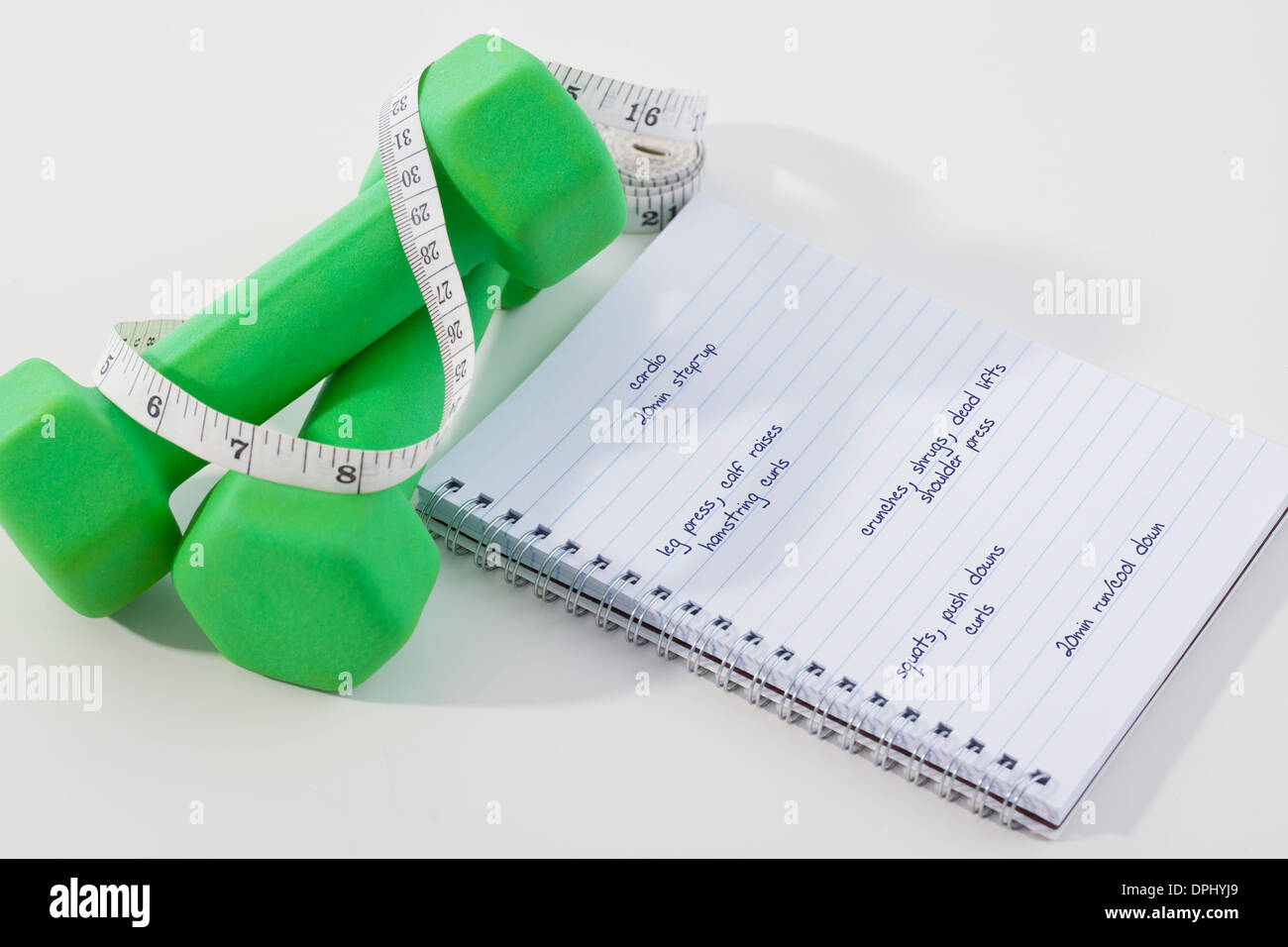 Dumbbells, measuring tape and notebook Stock Photo - Alamy