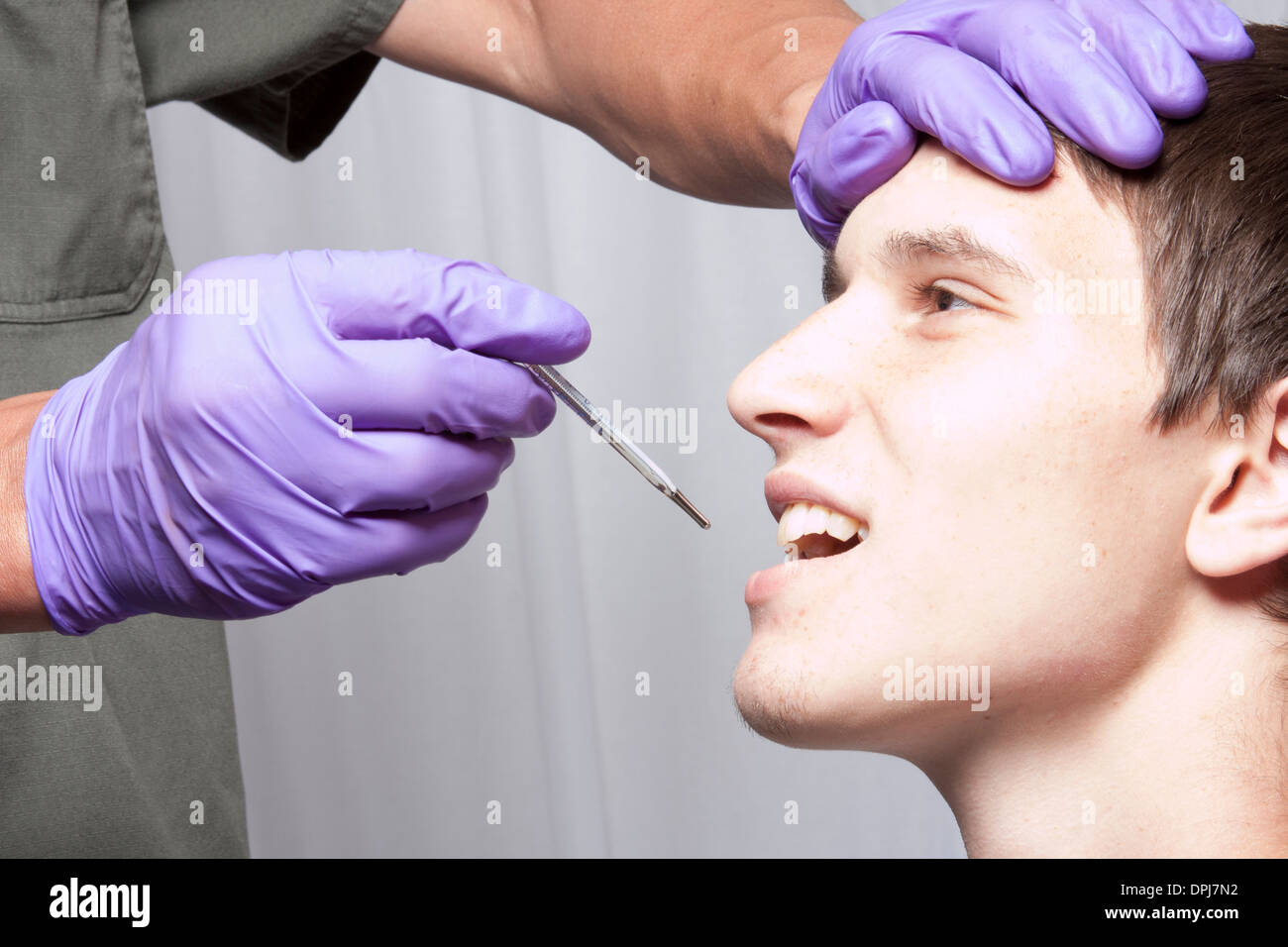 A medical staff person taking the temperature of a teenager Stock Photo ...