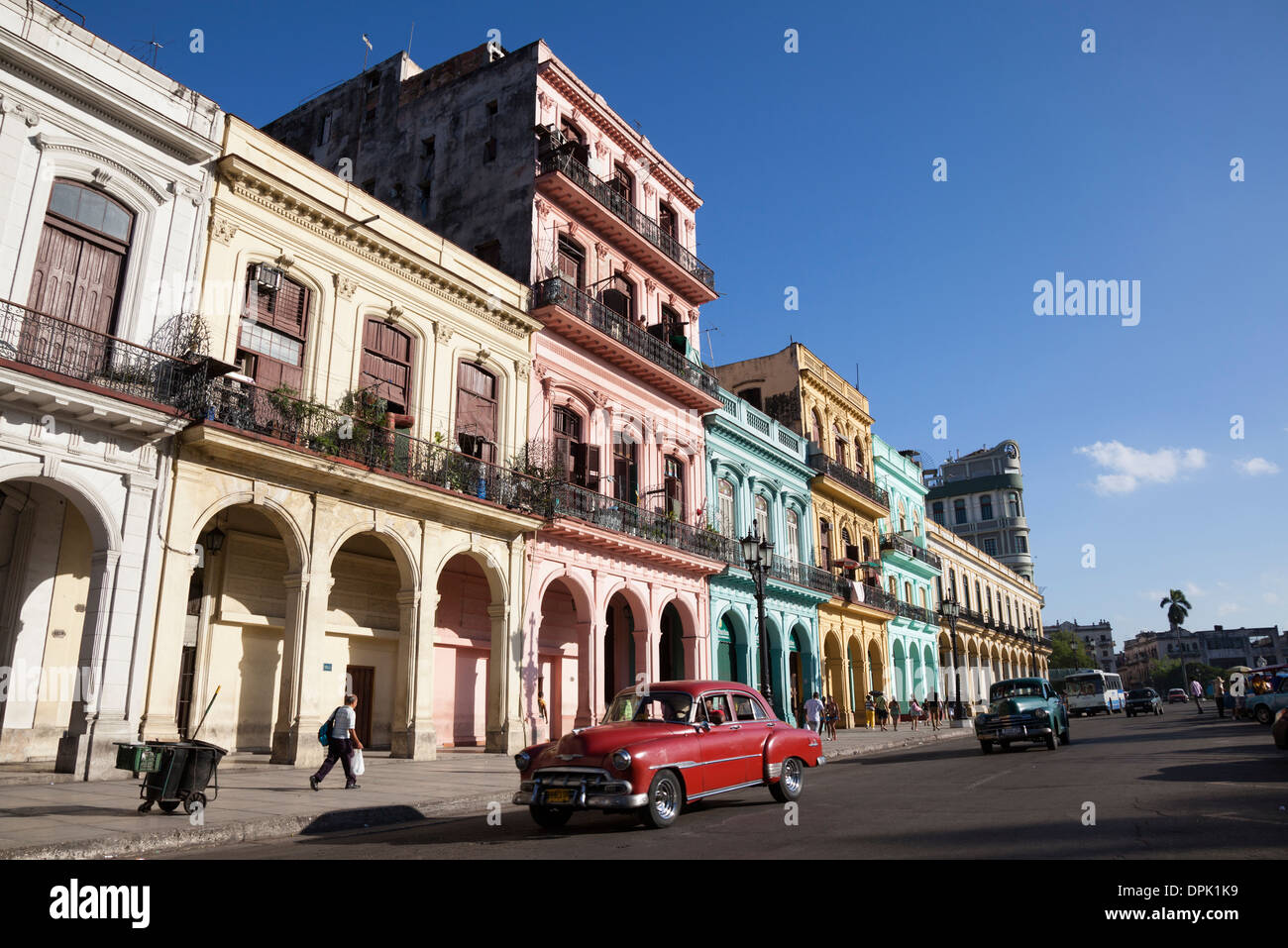 Vintage American vehicles pass colonial period buildings in Havana ...