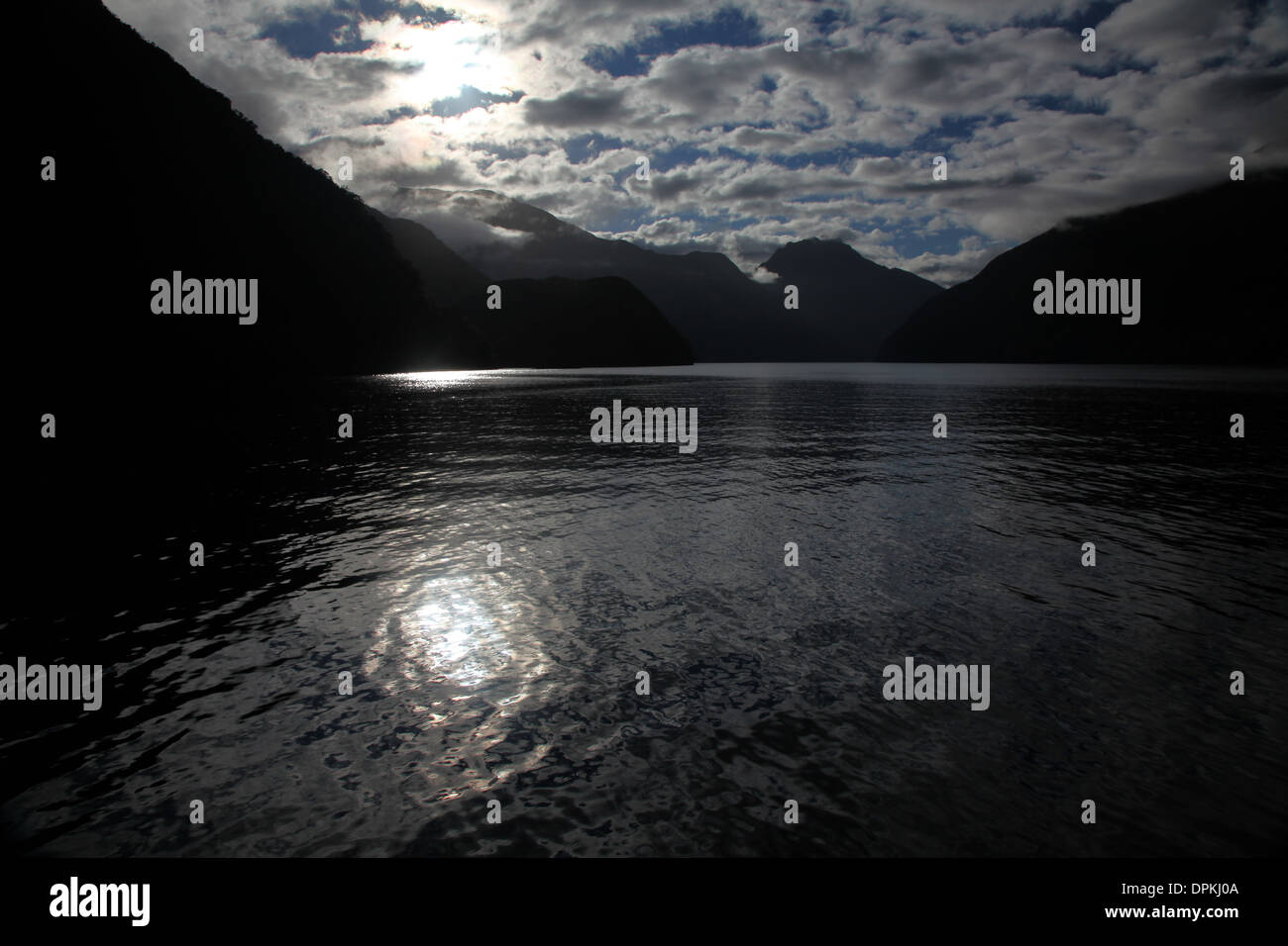 Doubtful sound awakens with mountains silhouetted on a black brooding ...