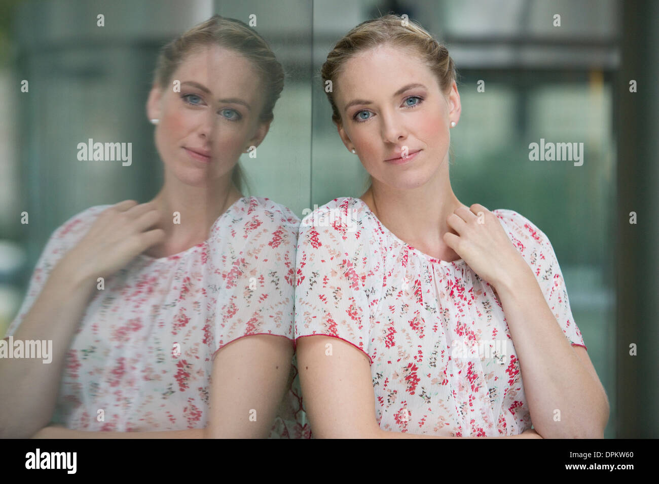 Portrait of young woman leaning against a window Stock Photo - Alamy