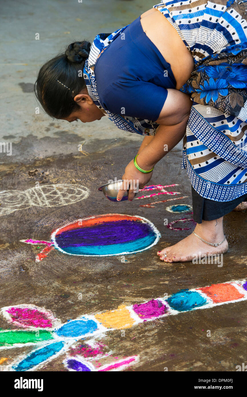 Indian woman making Rangoli festival coloured powder designs at ...