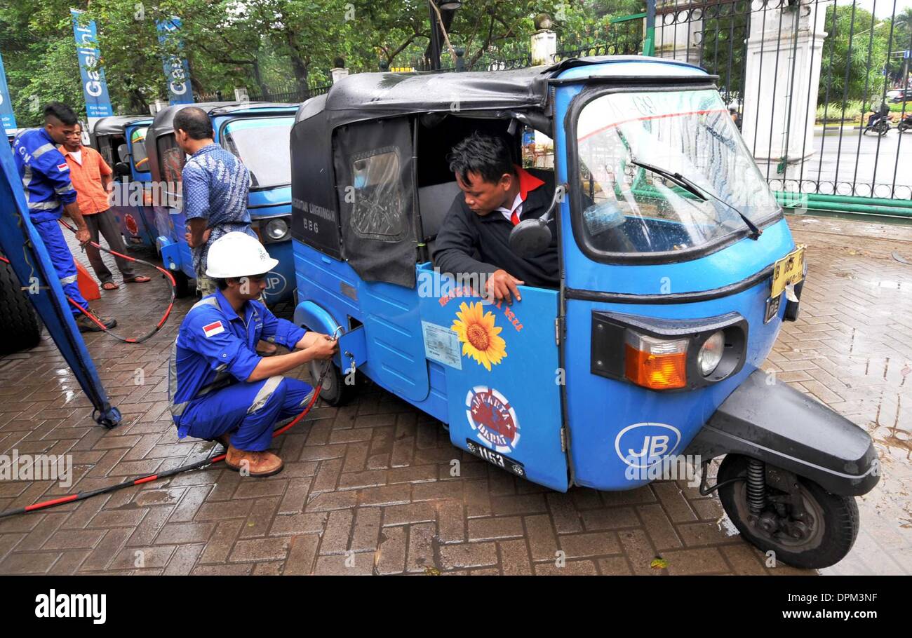 Jakarta, Indonesia. 15th Jan, 2014. An official refuels a rickshaw with ...