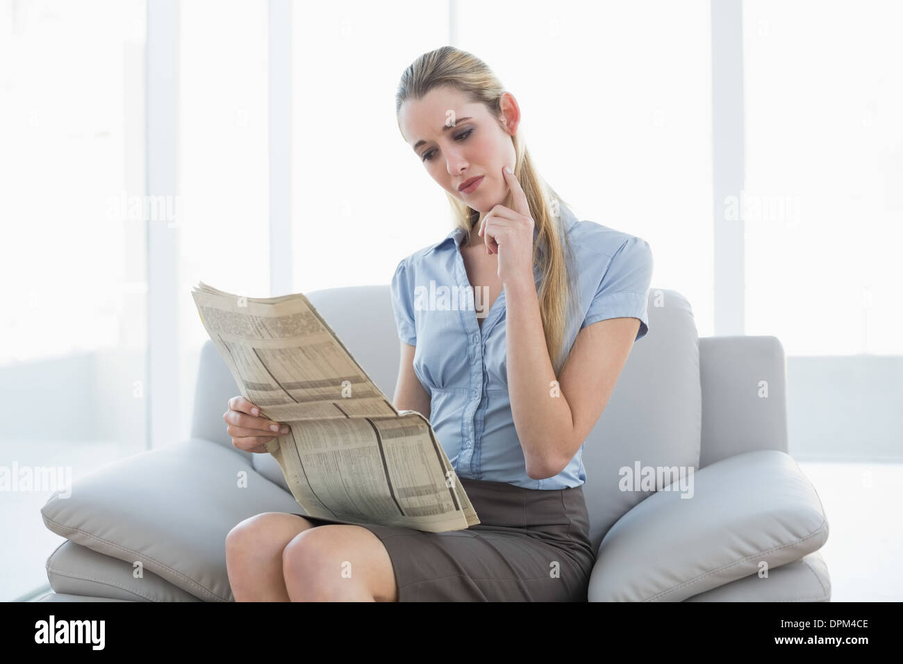 Blonde girl reading newspaper hi-res stock photography and images - Alamy