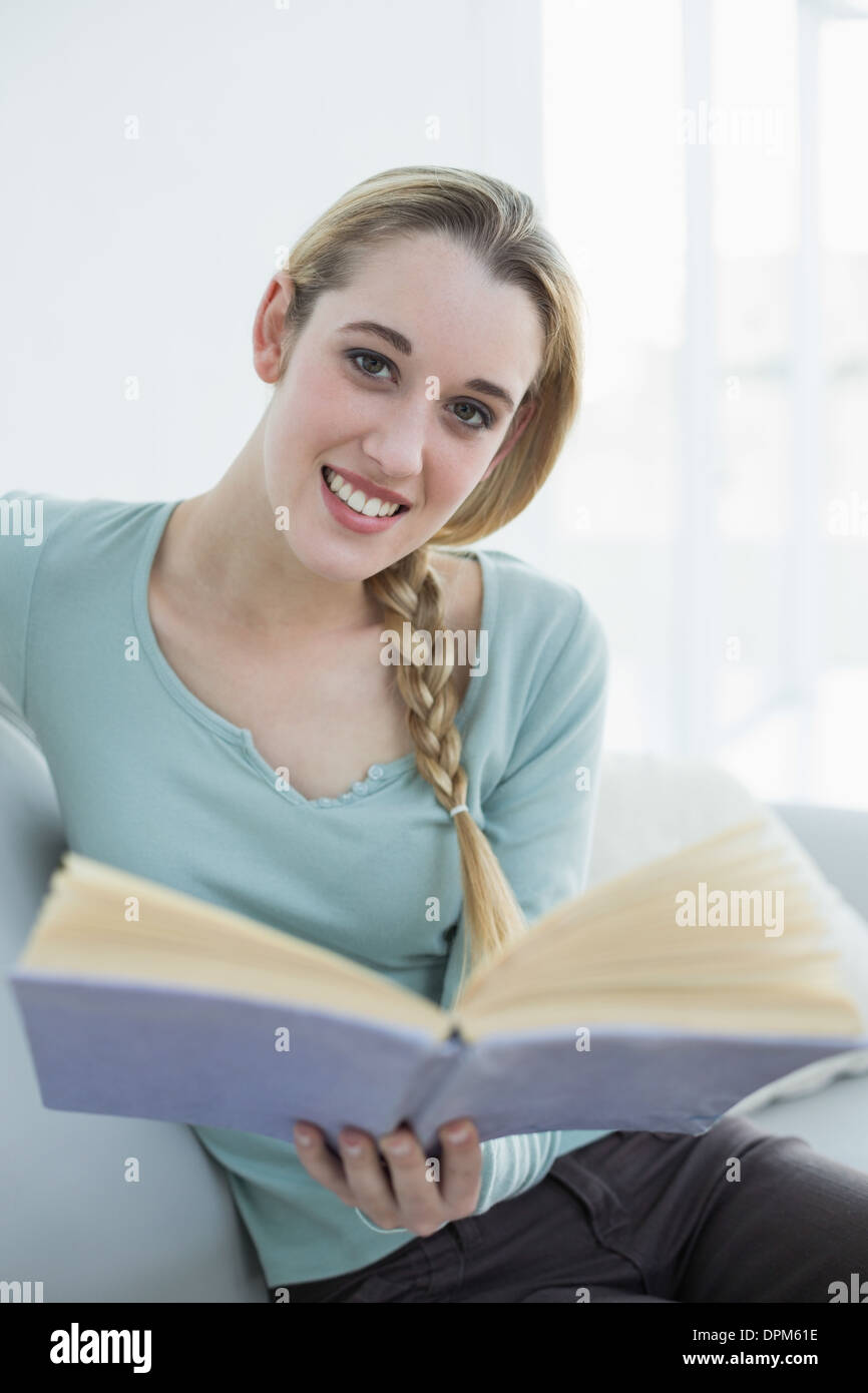 Cute calm woman relaxing reading a book sitting in the living room ...