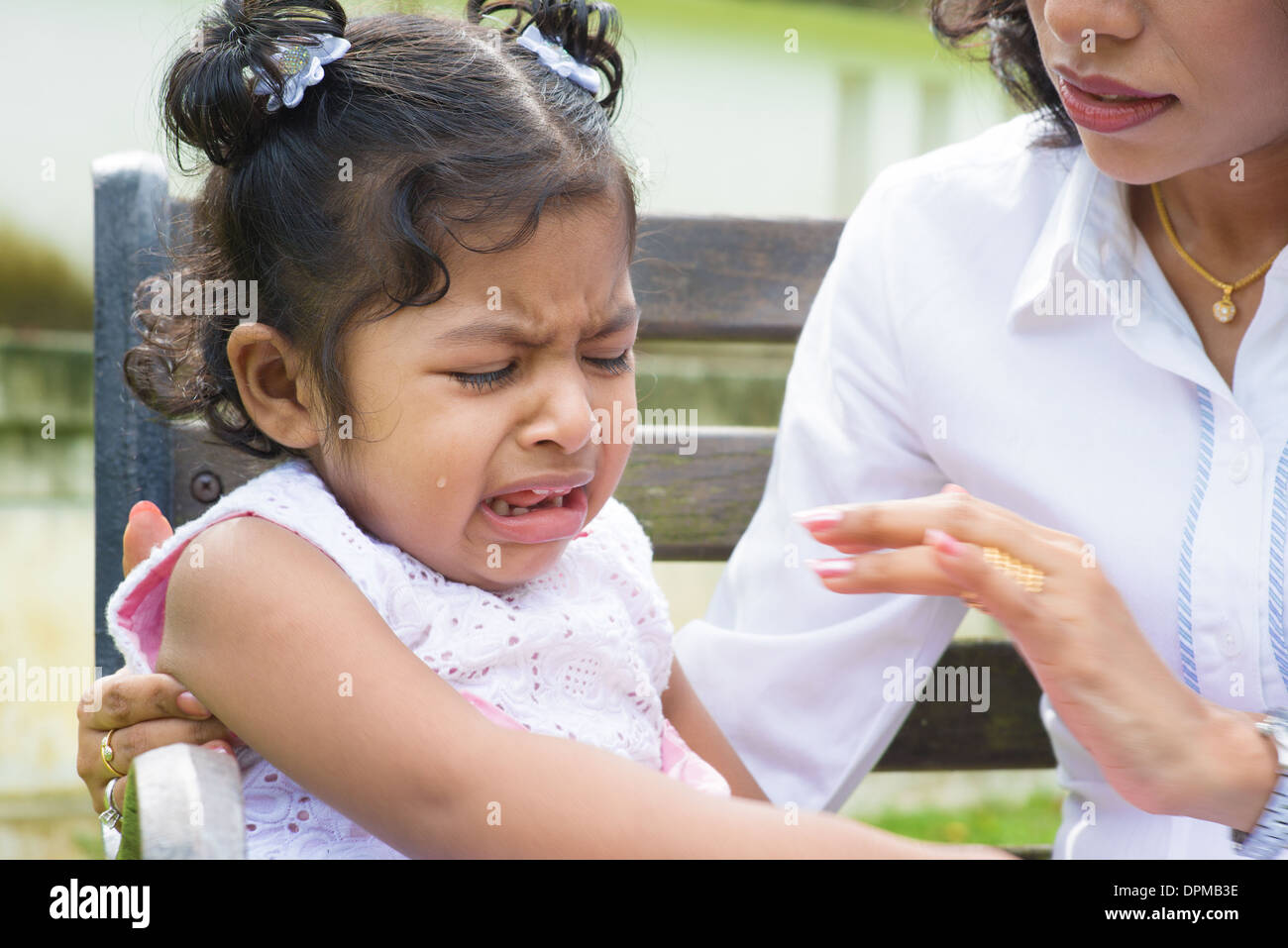 Indian family outdoor. Mother is comforting her crying daughter Stock ...