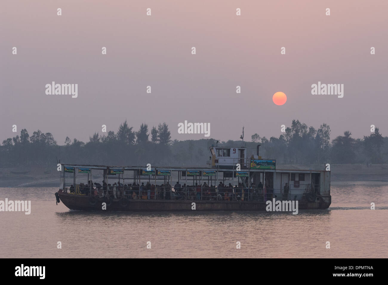 Crowded ferry boat full of pilgrims heading to Sagar Island at sunset ...