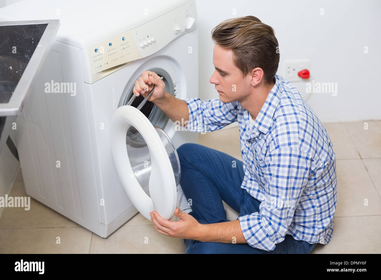 Technician repairing a washing machine Stock Photo - Alamy