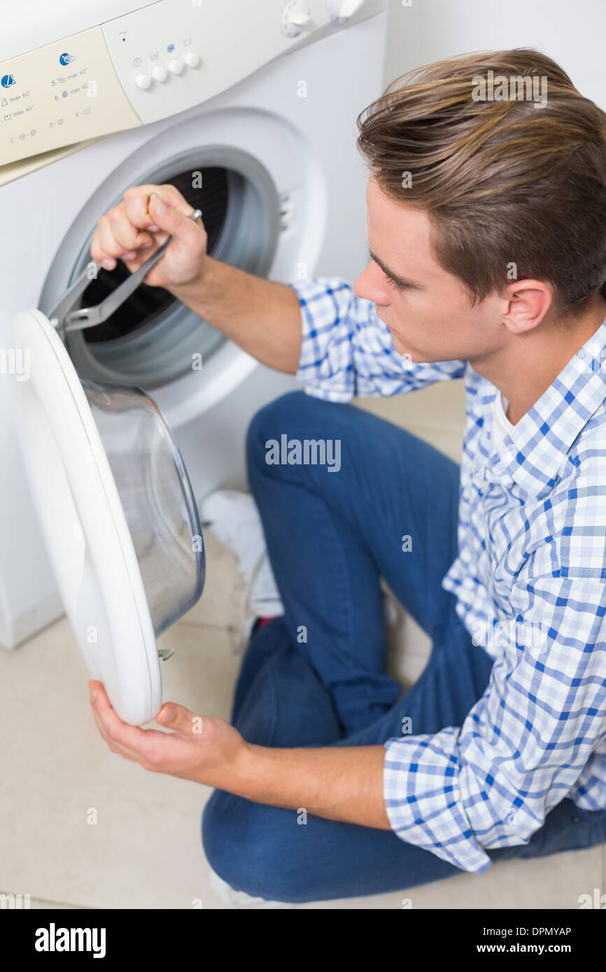 Technician repairing a washing machine Stock Photo - Alamy