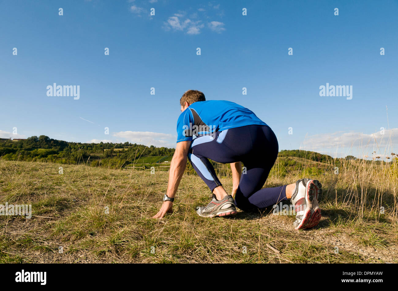 Man in starting position on a meadow Stock Photo - Alamy