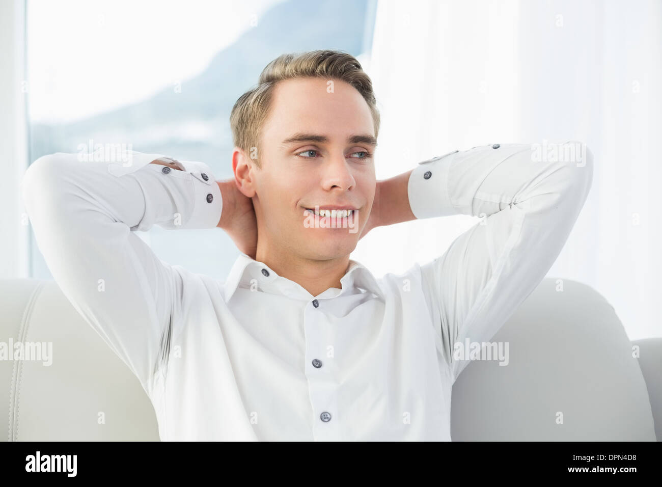 Smiling relaxed young man sitting on sofa Stock Photo - Alamy Smiling relaxed young man sitting on sofa Stock Photo - Alamy