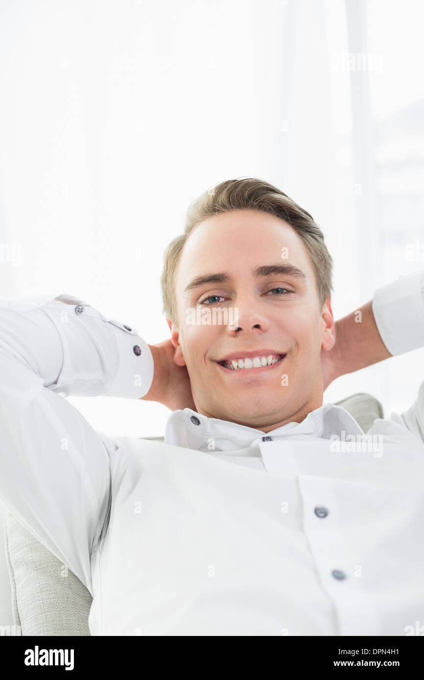 Smiling relaxed young man lying on sofa Stock Photo - Alamy