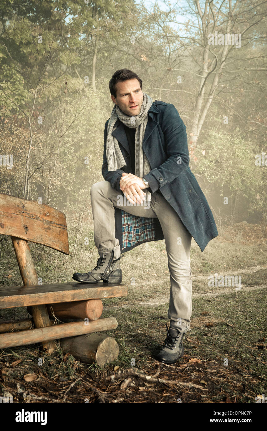 Young man standing bench tree hi-res stock photography and images - Alamy