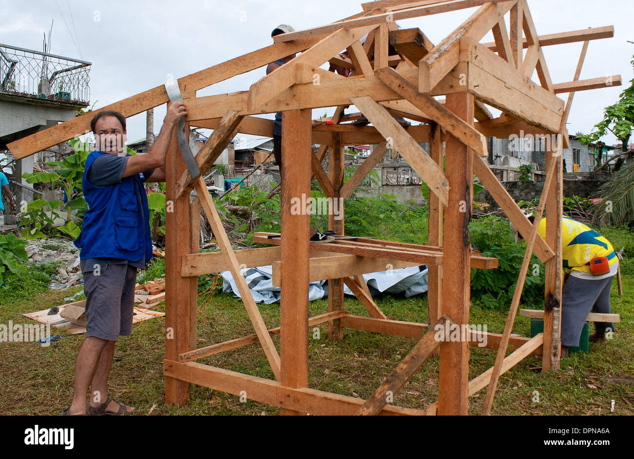 Tacloban, Germany. 15th Dec, 2013. Two men erect a wood hut in Tacloban ...