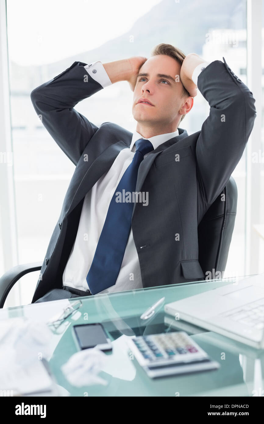 Worried young businessman at office desk Stock Photo - Alamy