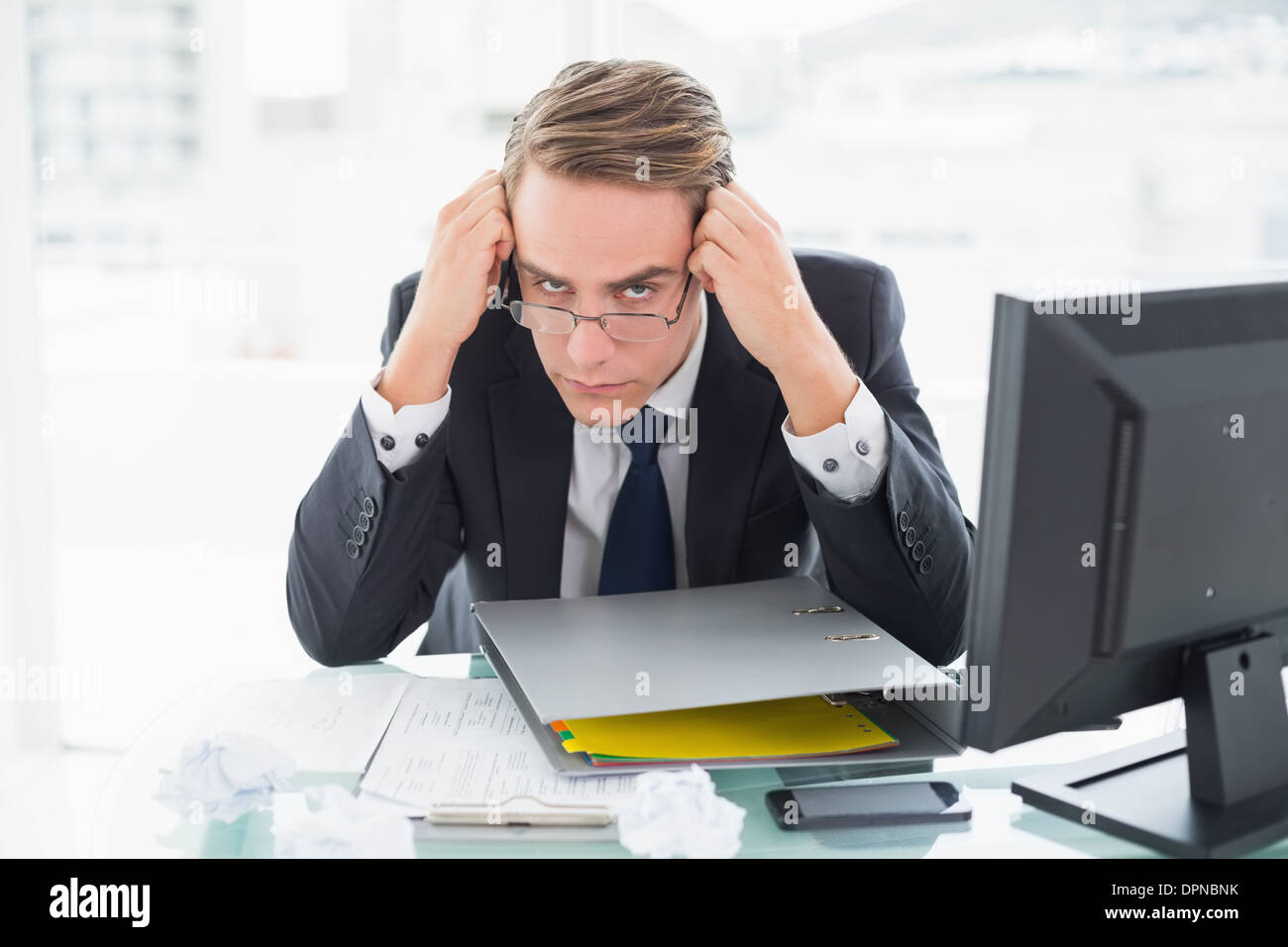 Businessman with documents and computer at office desk Stock Photo - Alamy