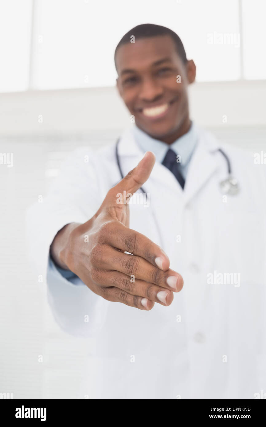 Smiling male doctor offering a handshake Stock Photo - Alamy